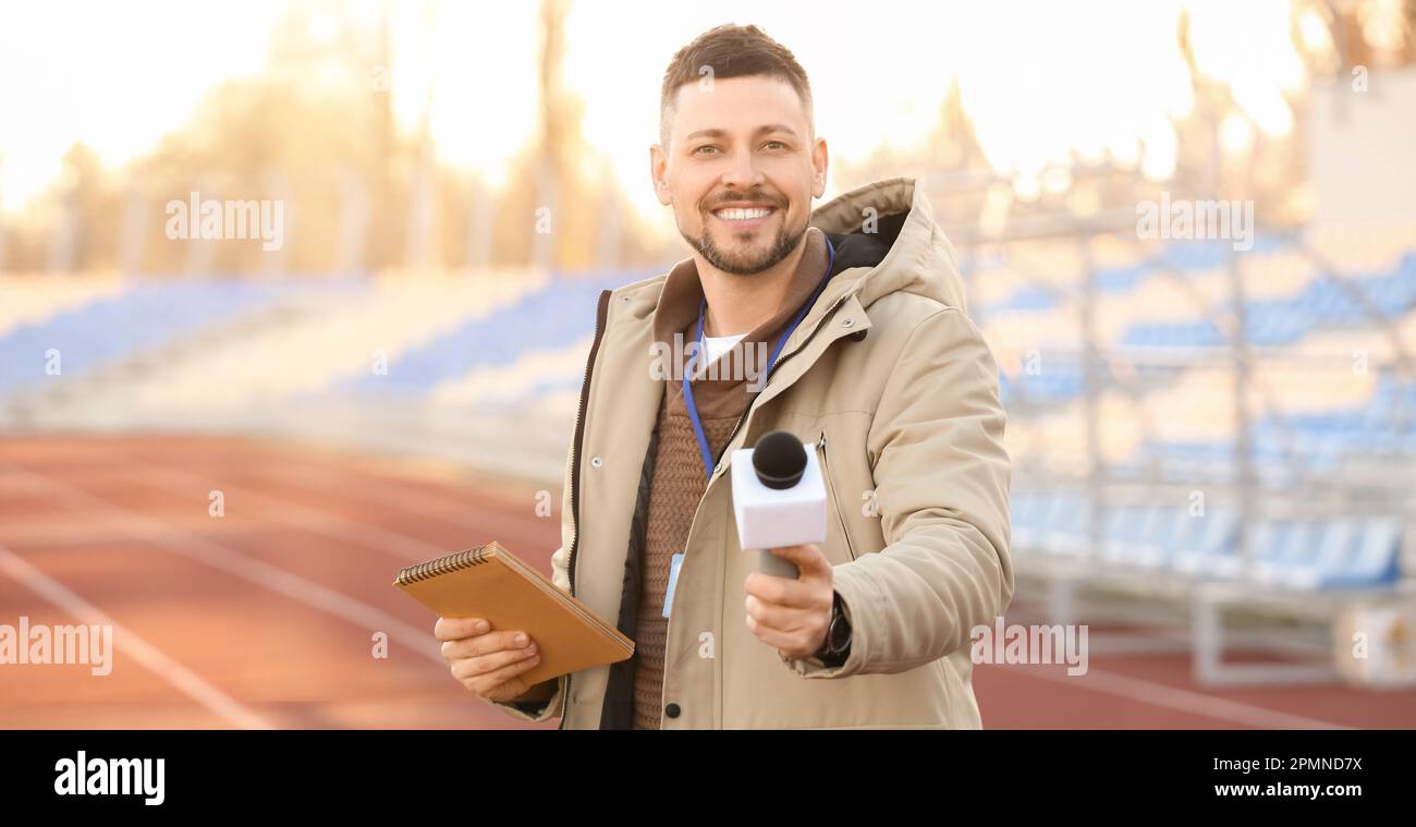 Male reporter with microphone at the stadium Stock Photo - Alamy