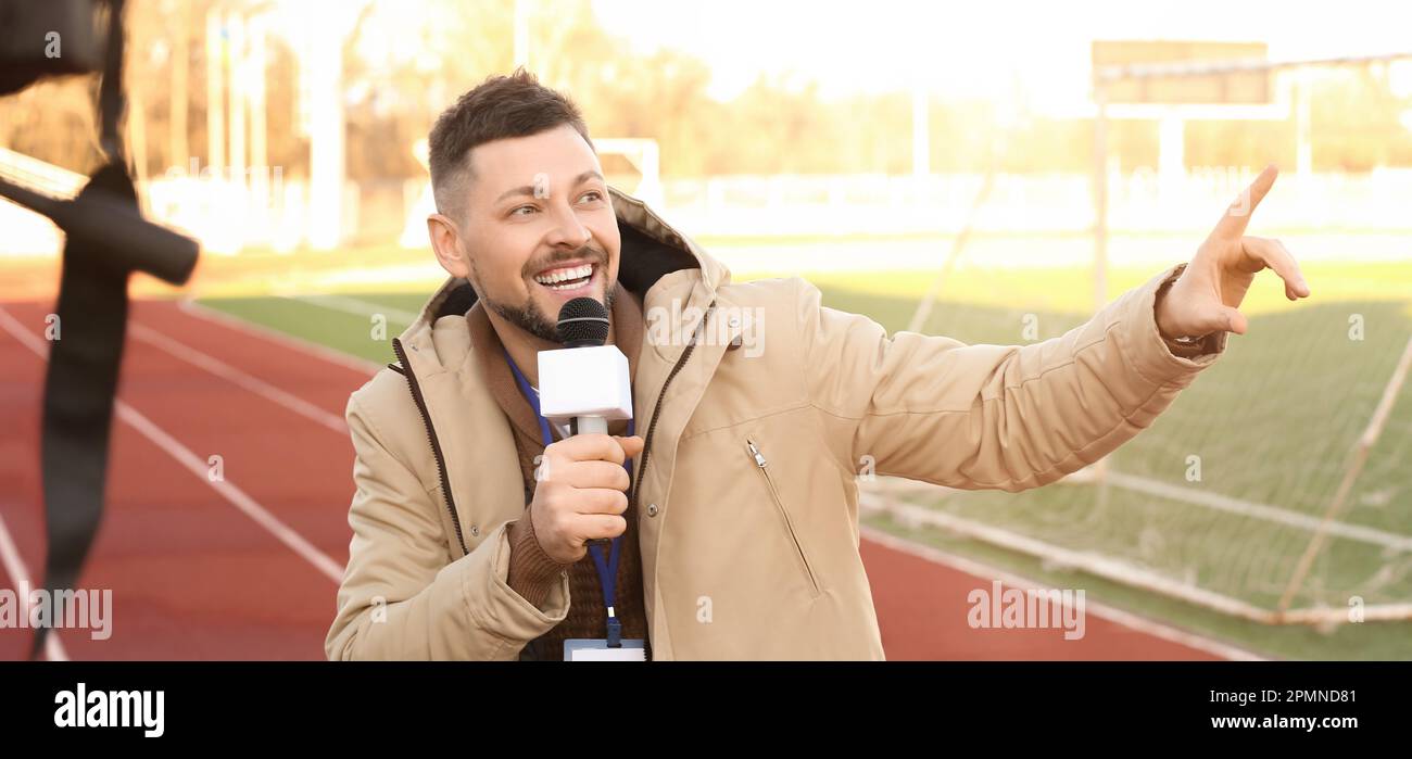 Male reporter with microphone at the stadium Stock Photo - Alamy