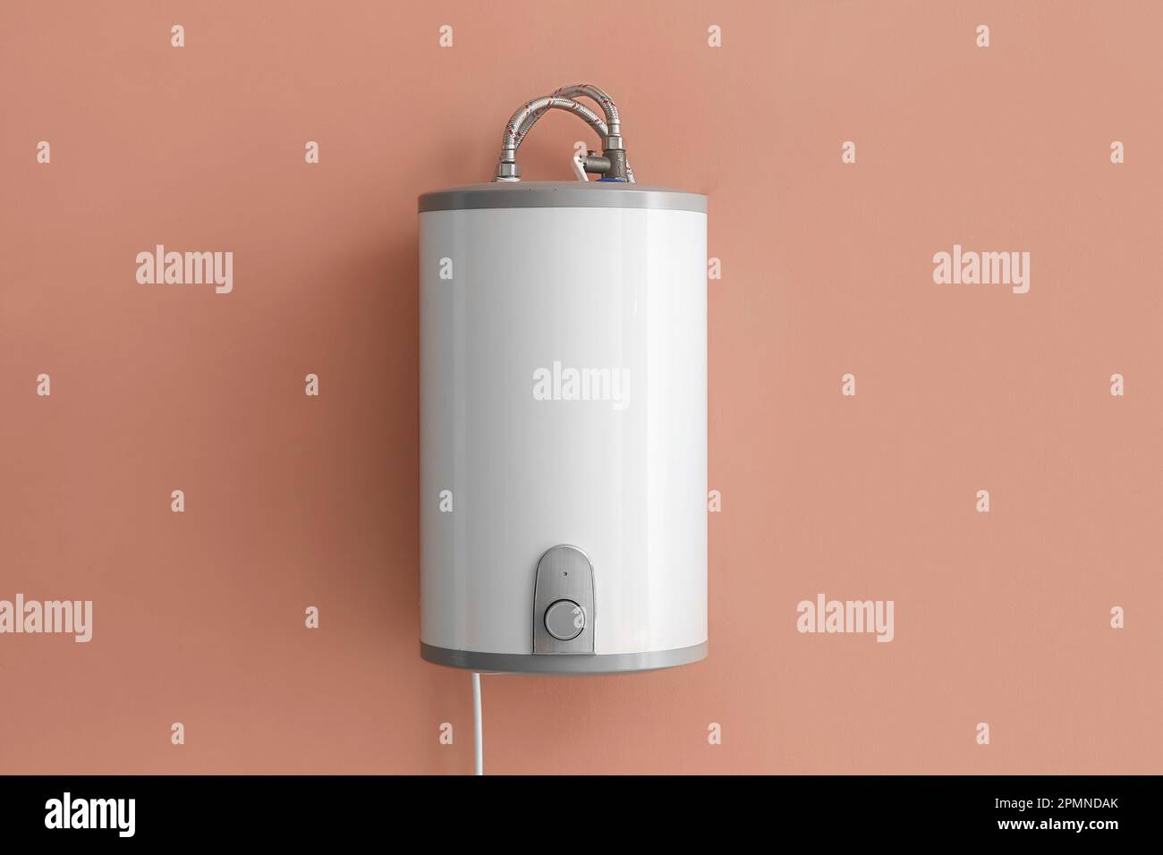 Modern electric boiler on color wall Stock Photo - Alamy