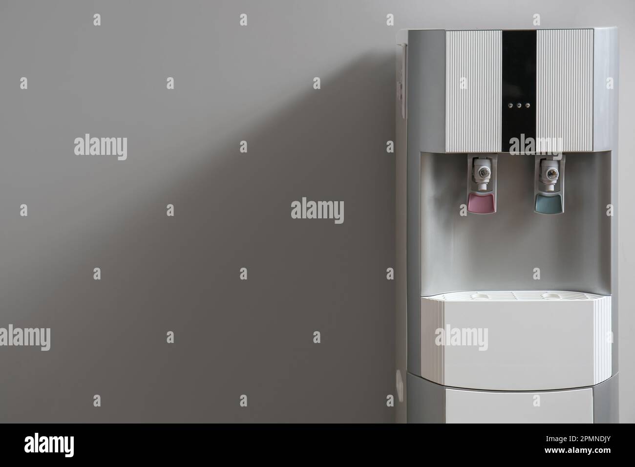 Modern water cooler on grey background Stock Photo - Alamy