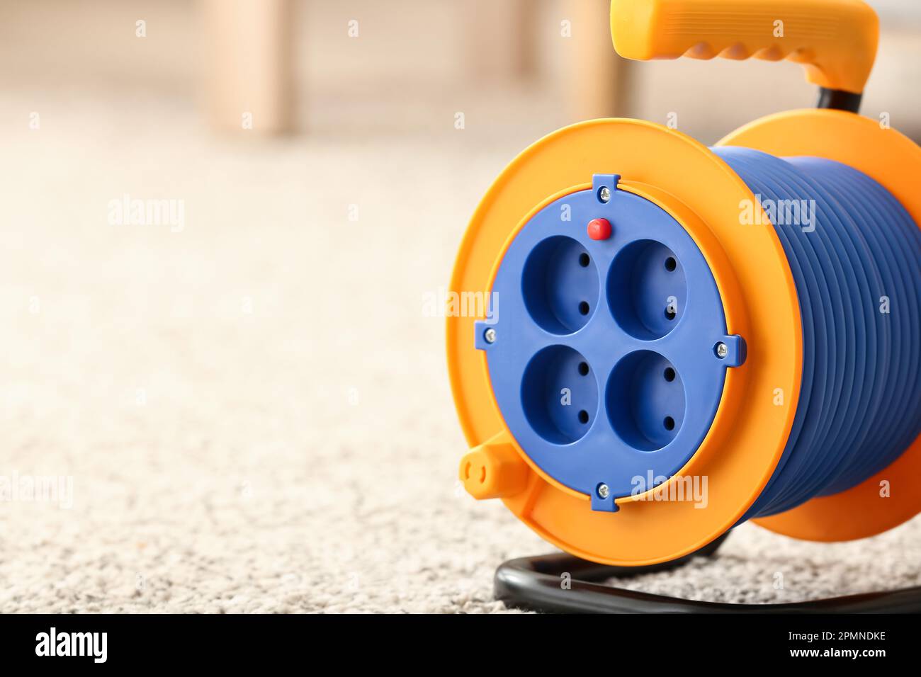Extension electric cable reel on carpet, closeup Stock Photo - Alamy