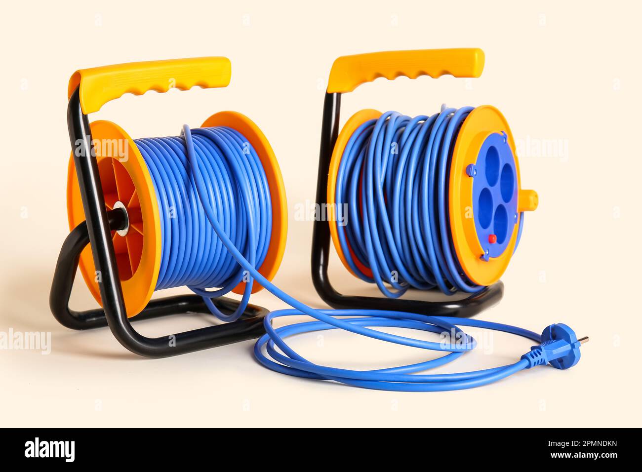 Extension electric cable reels on light background Stock Photo - Alamy