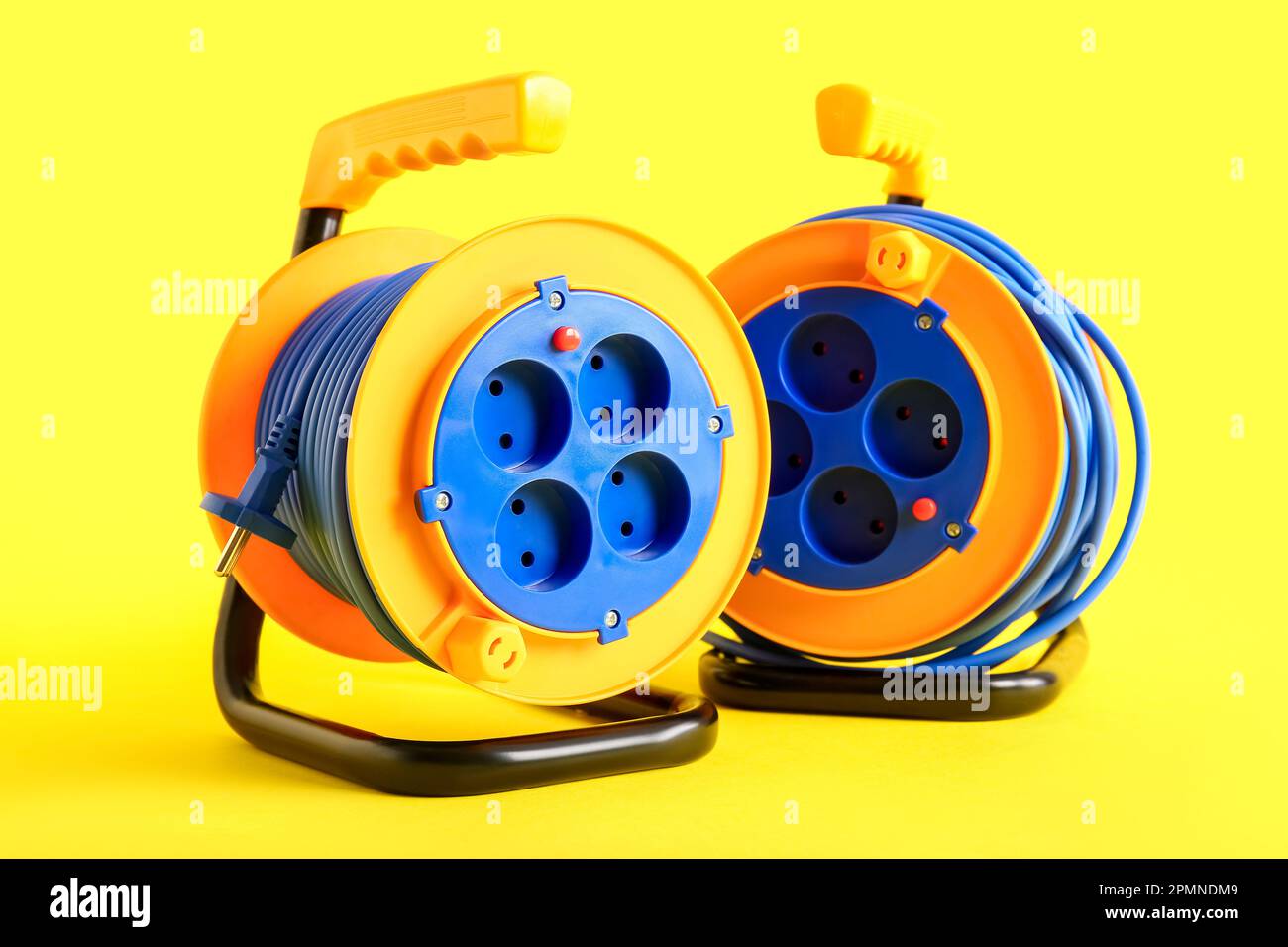Extension electric cable reels on yellow background Stock Photo - Alamy