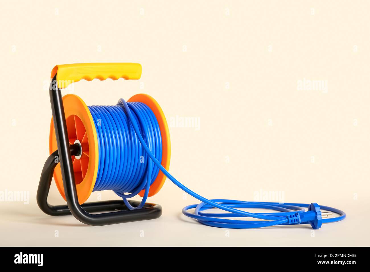 Extension electric cable reel on light background Stock Photo - Alamy
