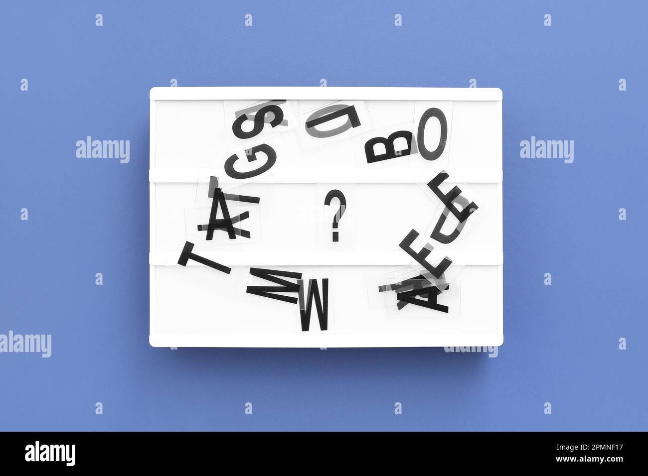Board with question mark and letters on blue background Stock Photo - Alamy