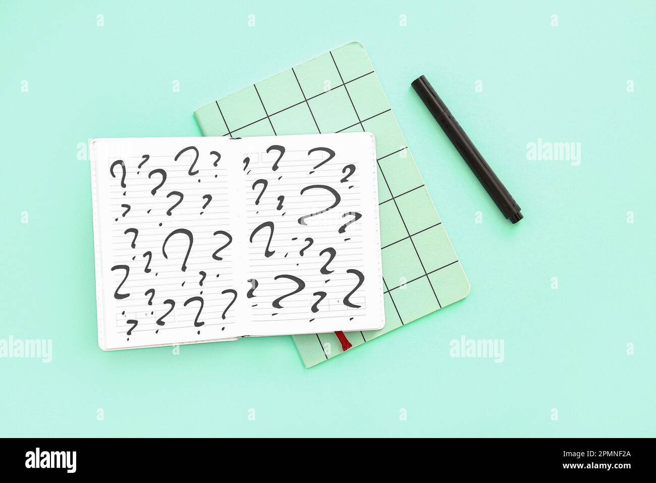 Notebooks with question marks and marker on green background Stock ...