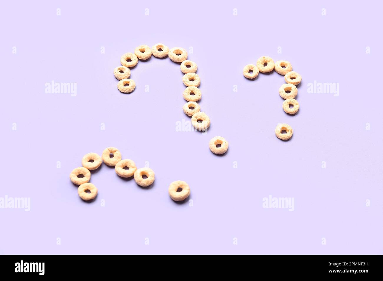 Question marks made of cereal rings on lilac background Stock Photo - Alamy