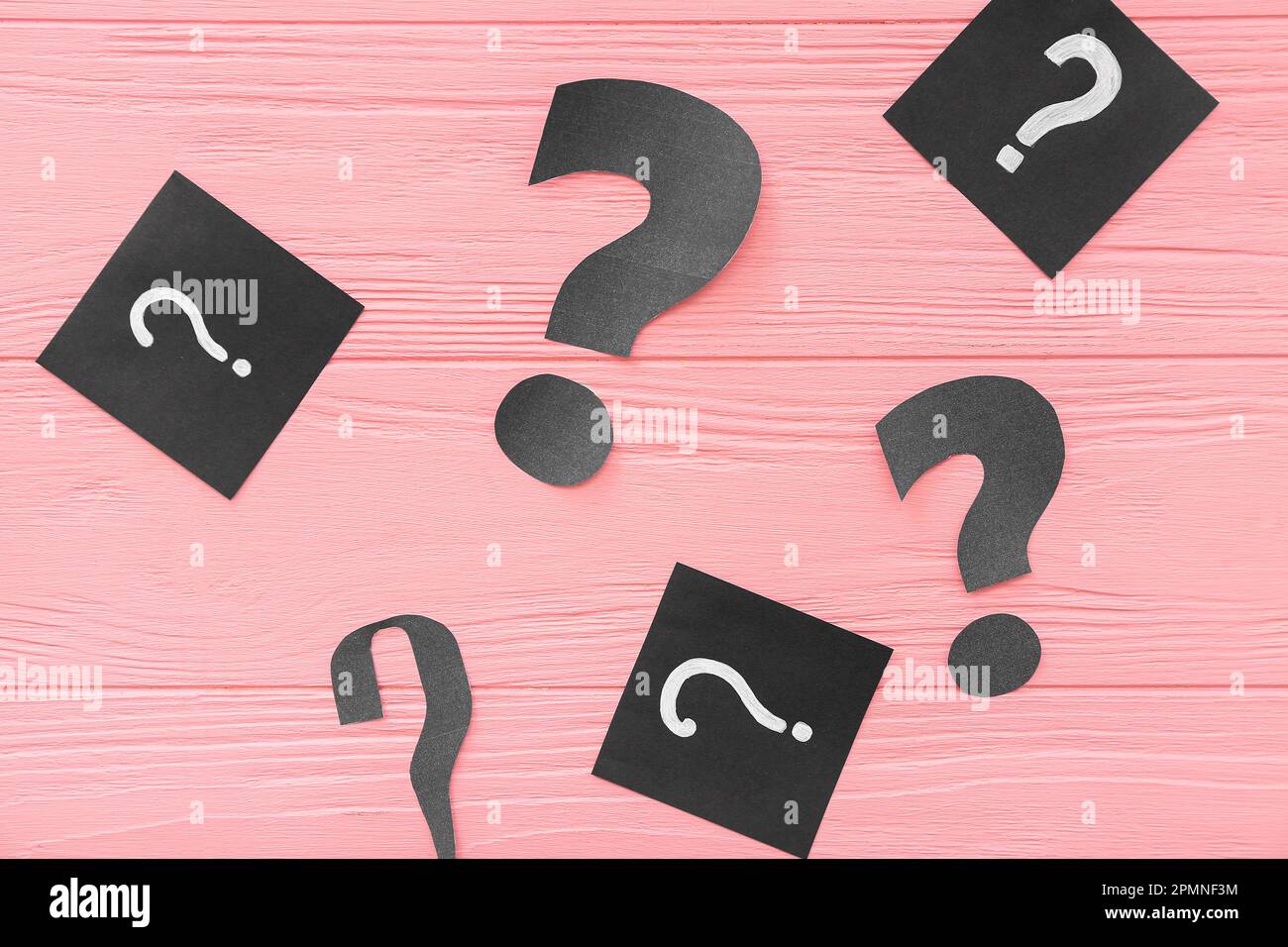 Paper question marks on pink wooden background Stock Photo - Alamy