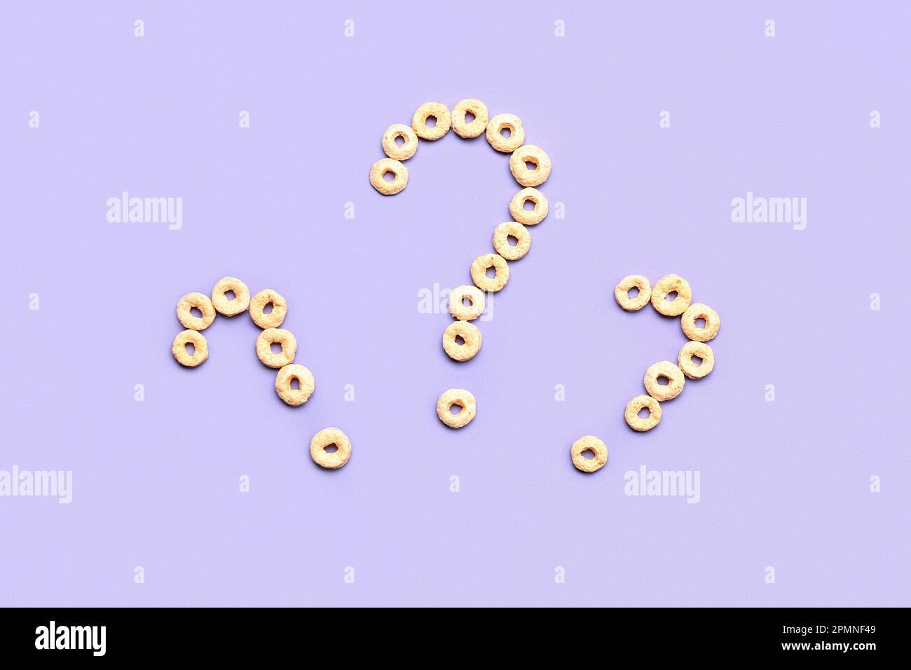 Question marks made of cereal rings on lilac background Stock Photo - Alamy