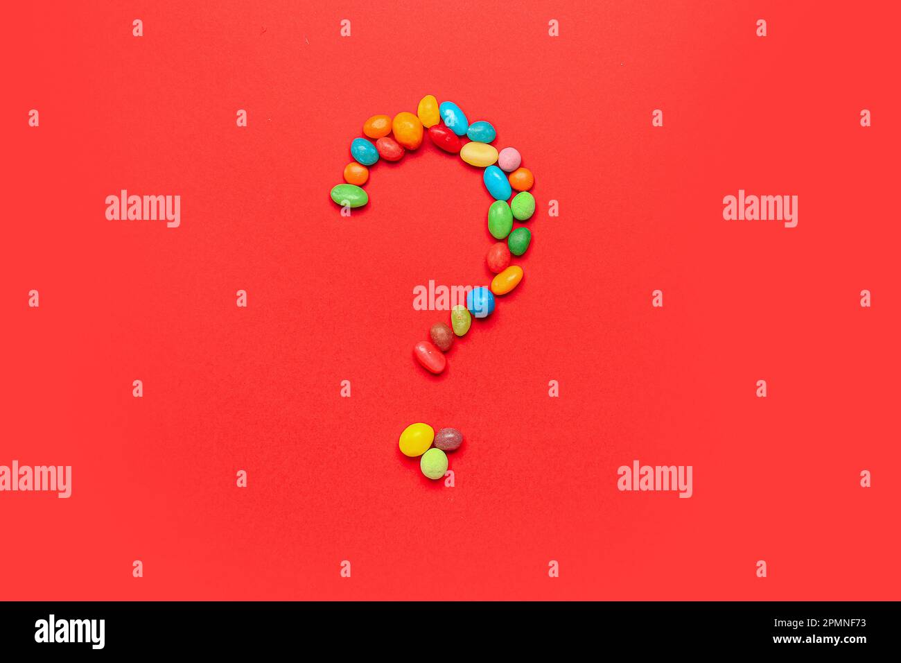 Question mark made of candies on red background Stock Photo - Alamy