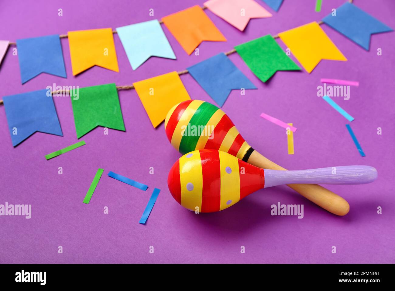 Mexican maracas with paper flags and confetti on purple background ...