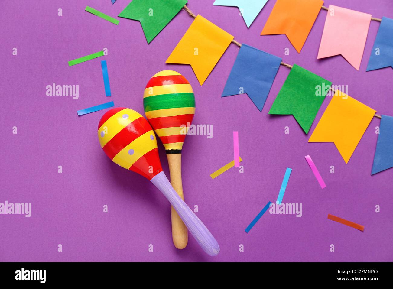 Mexican maracas with paper flags and confetti on purple background ...