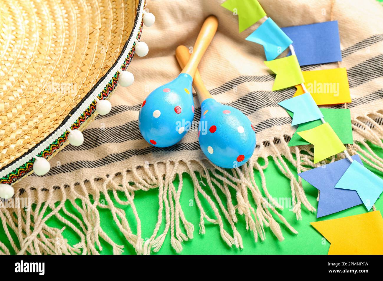 Mexican maracas with sombrero hat, serape and flags on green background ...