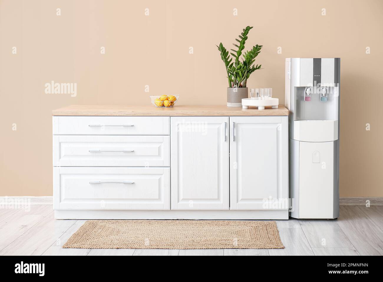 Interior of kitchen with modern water cooler near beige wall Stock ...
