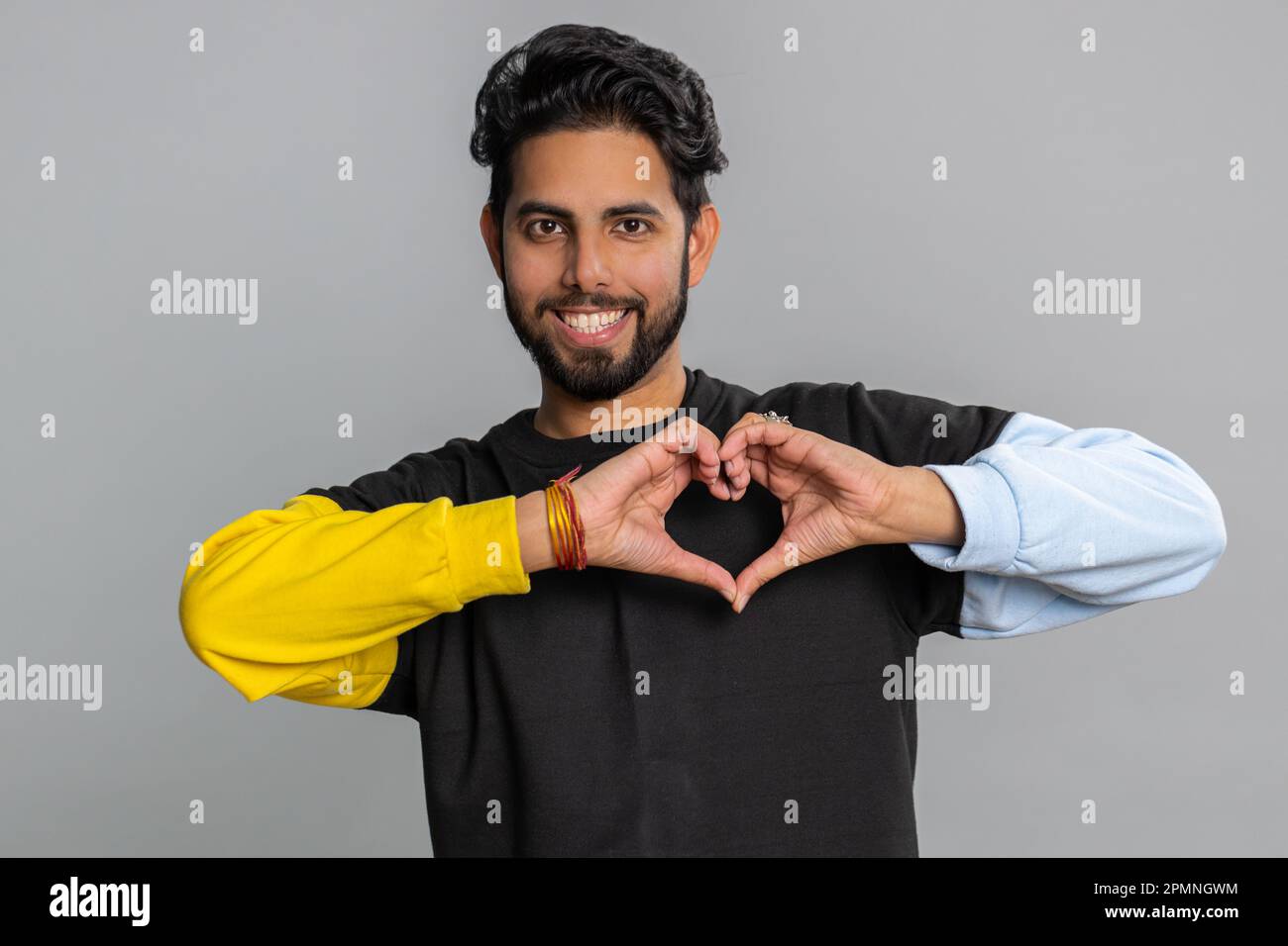 Man in love. Smiling bearded indian man 25 years old makes heart ...