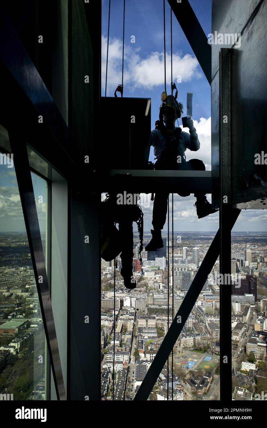 ROTTERDAM - 14/04/2023, Abseilers hang on the 57th floor of the ...