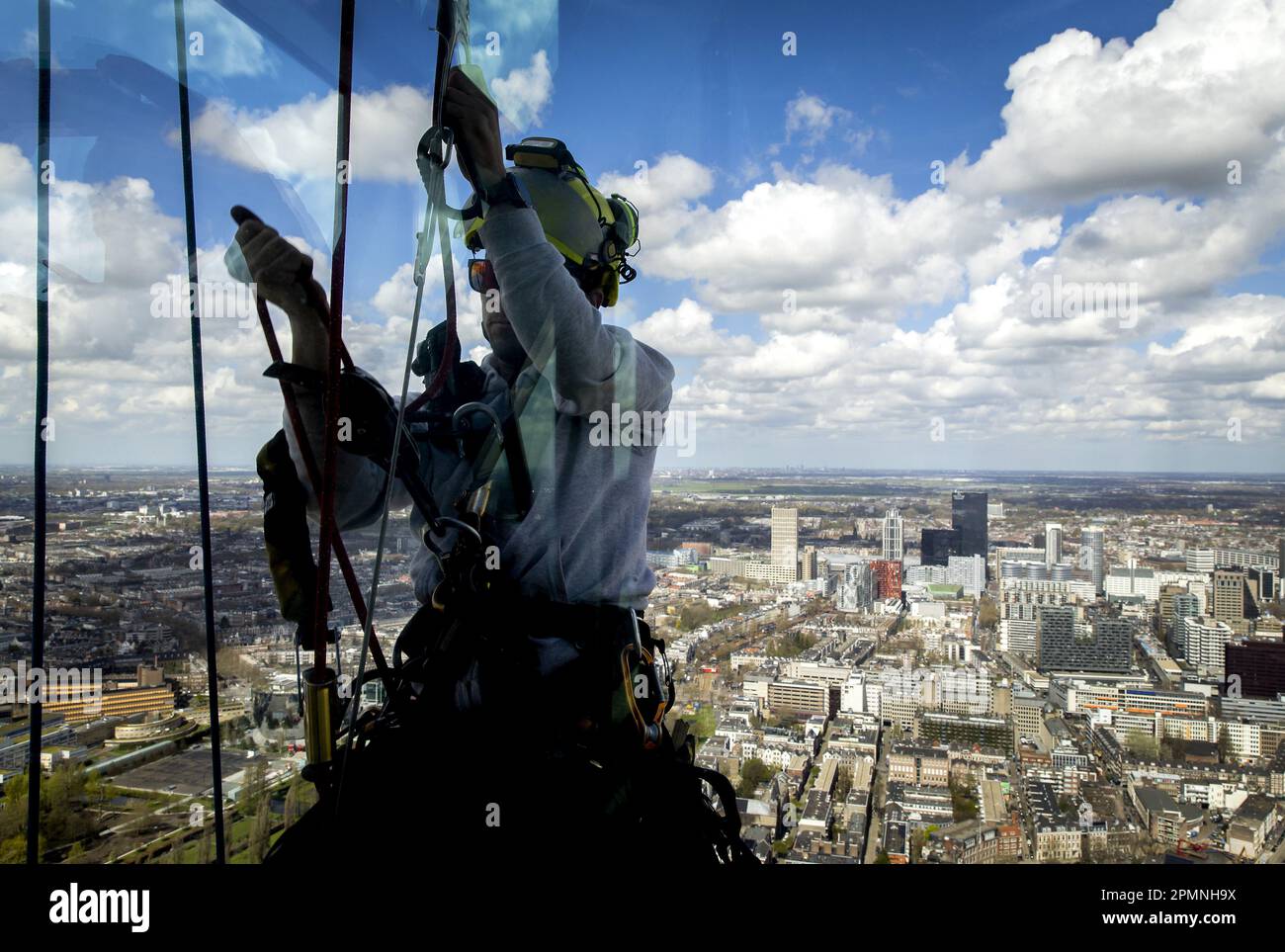 ROTTERDAM - 14/04/2023, Abseilers hang on the 57th floor of the ...