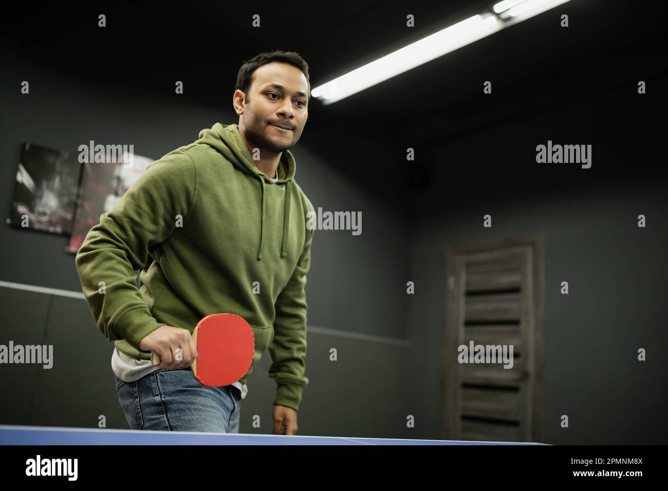 Focused indian man playing table tennis in gaming club,stock image ...
