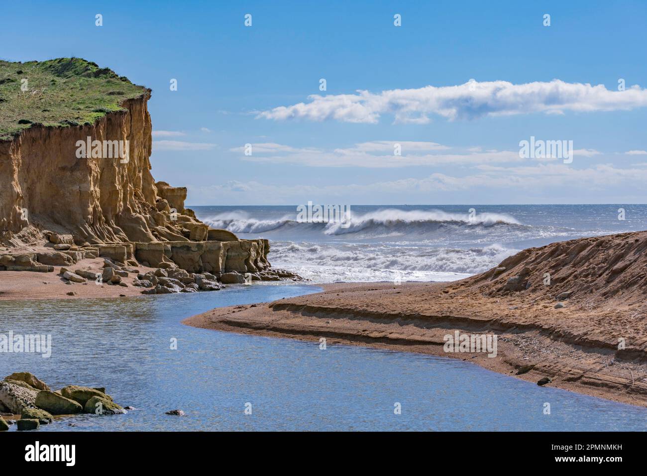 The river Bride flowing into the crashing sea at Burton Freshwater ...