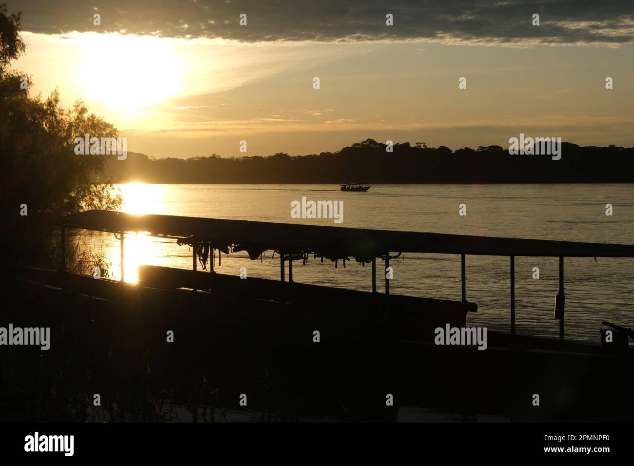 Sunset over Amazon river with boat cloud and forest background at ...
