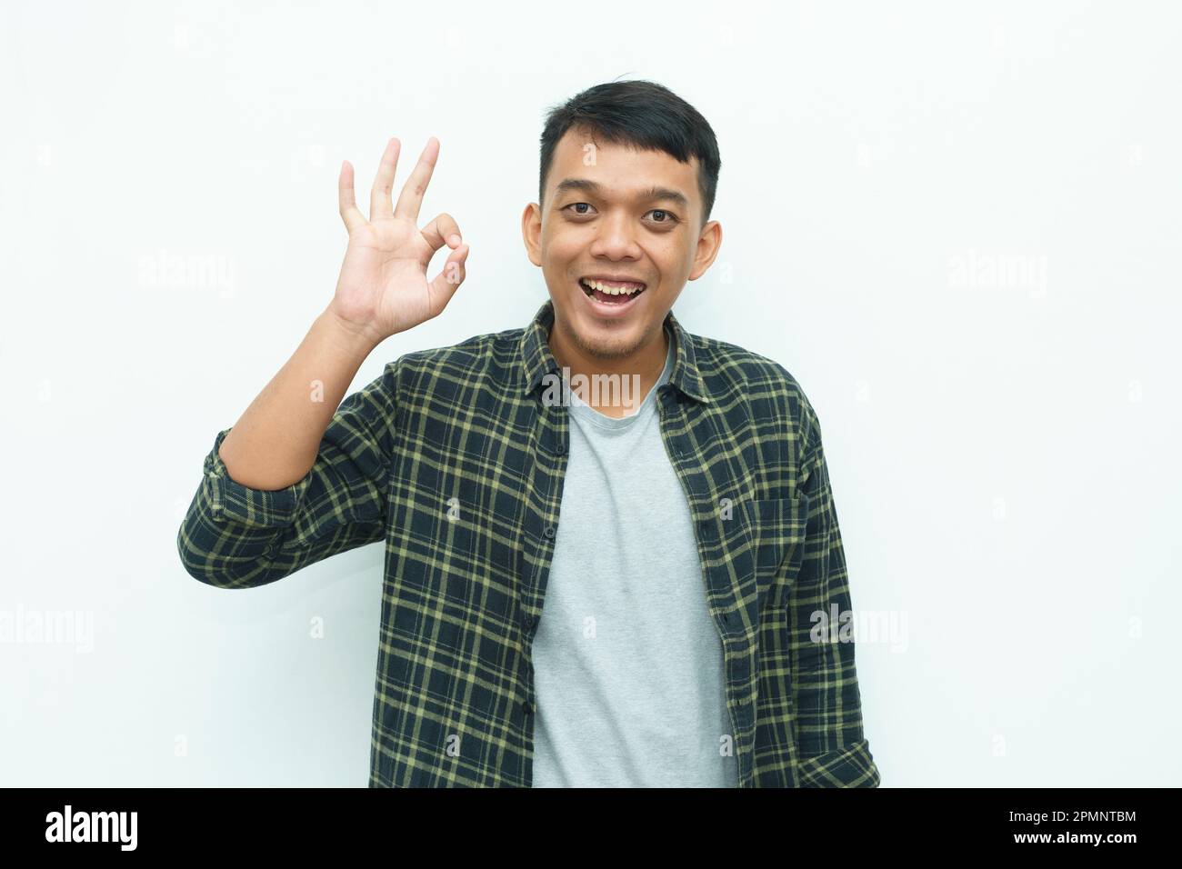 Young Asian man smiling and giving OK sign or zero number gesture with ...