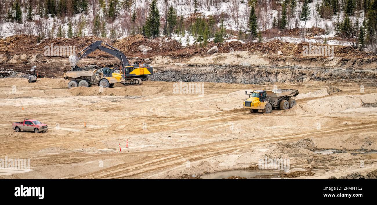 Dumpers and excavator performing excavation work during the ...