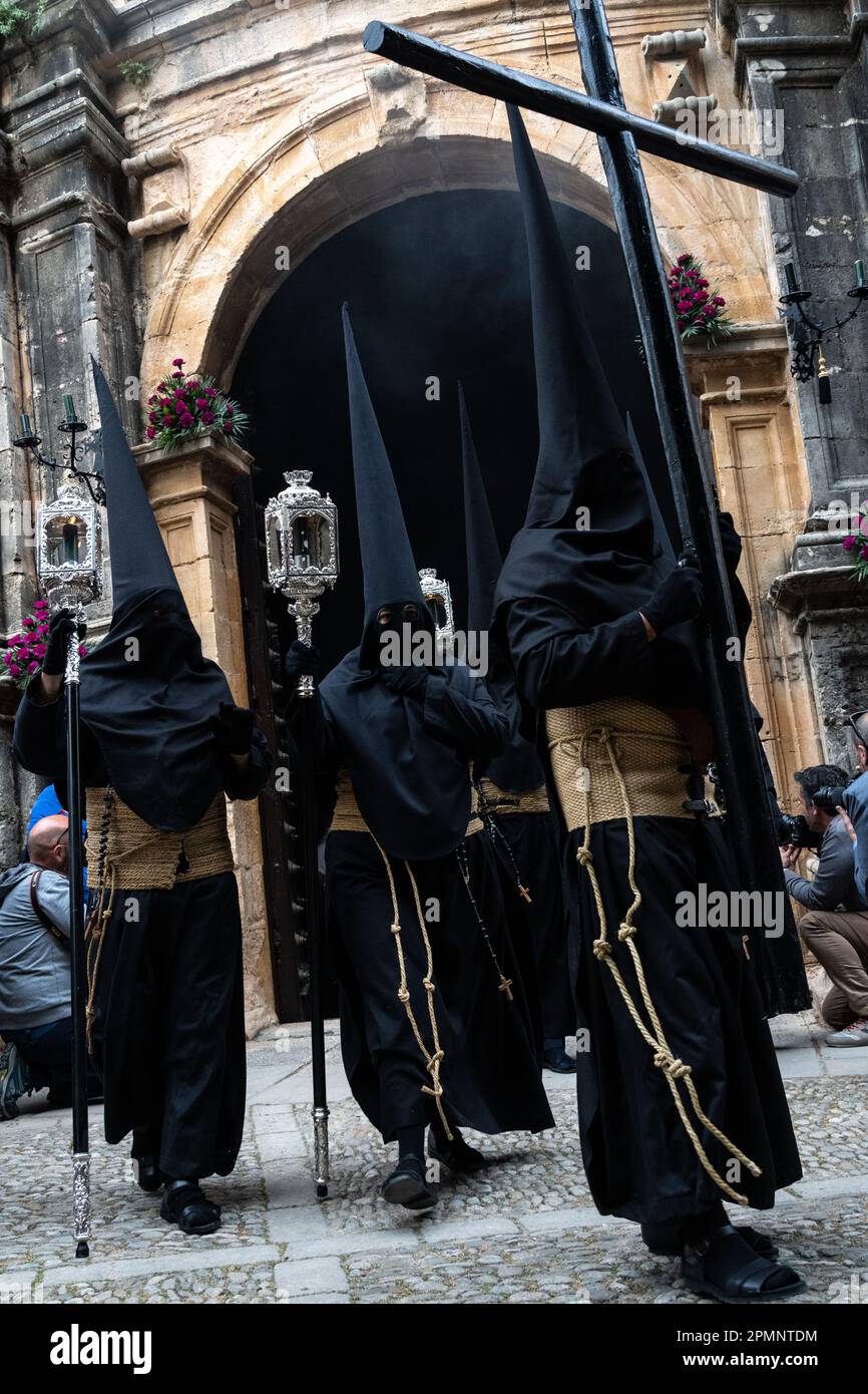 Penitents wearing black pointed hoods carry wooden cross from St. Mary ...