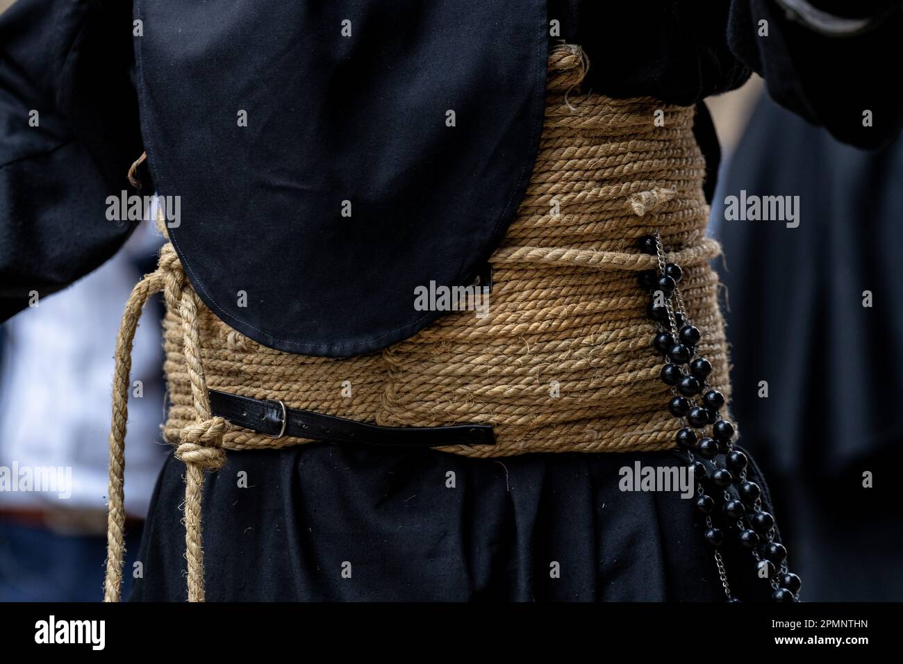 A Catholic penitent wears rope wrapped around his waist as he processes ...