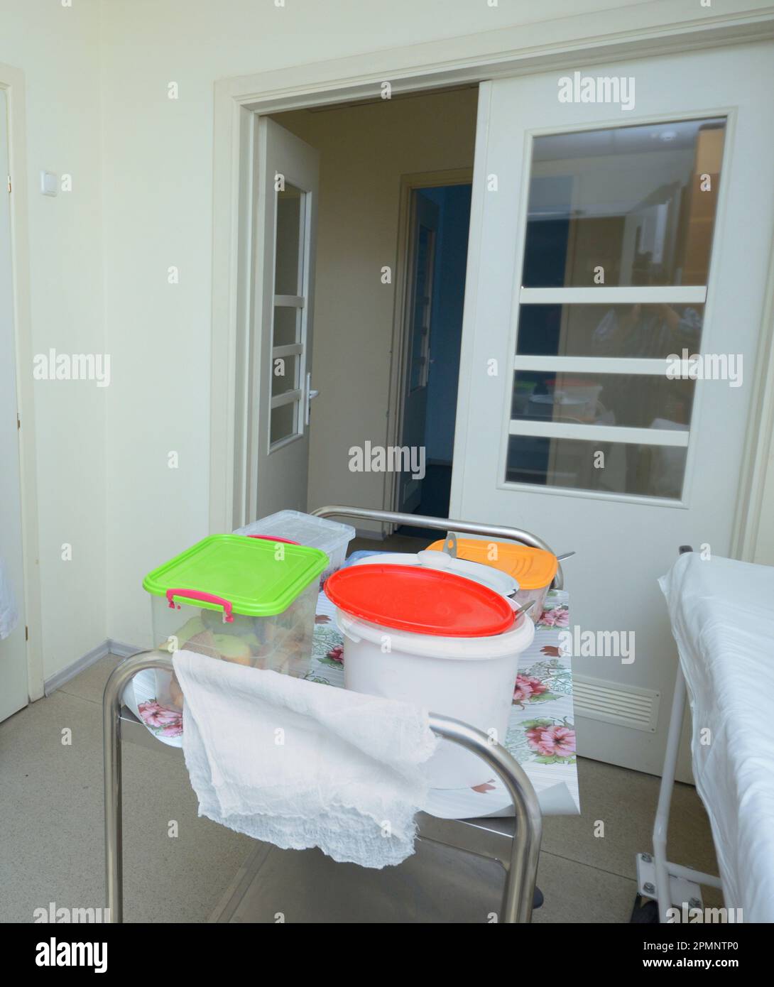 Tray trolley with food in pots for patients left in a lobby of a ...