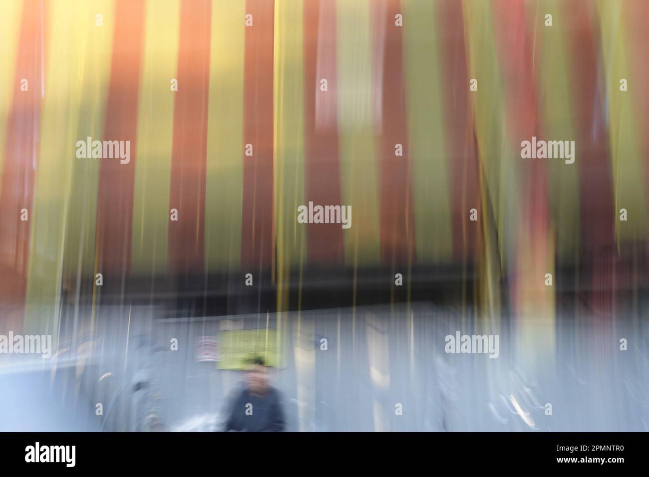 Blurry human figure next to corrugated fence with under construction ...