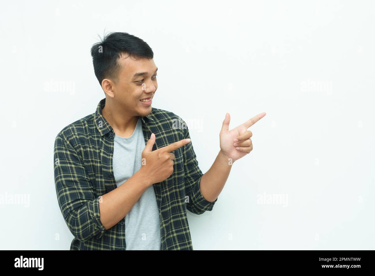 Young Asian man smiling and the finger pointing to the left side with ...