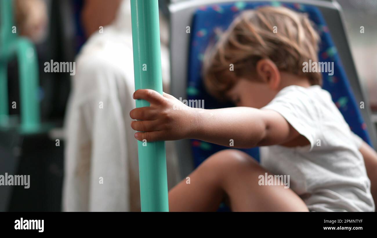Child hand closeup holding into metal bar inside bus tram ...