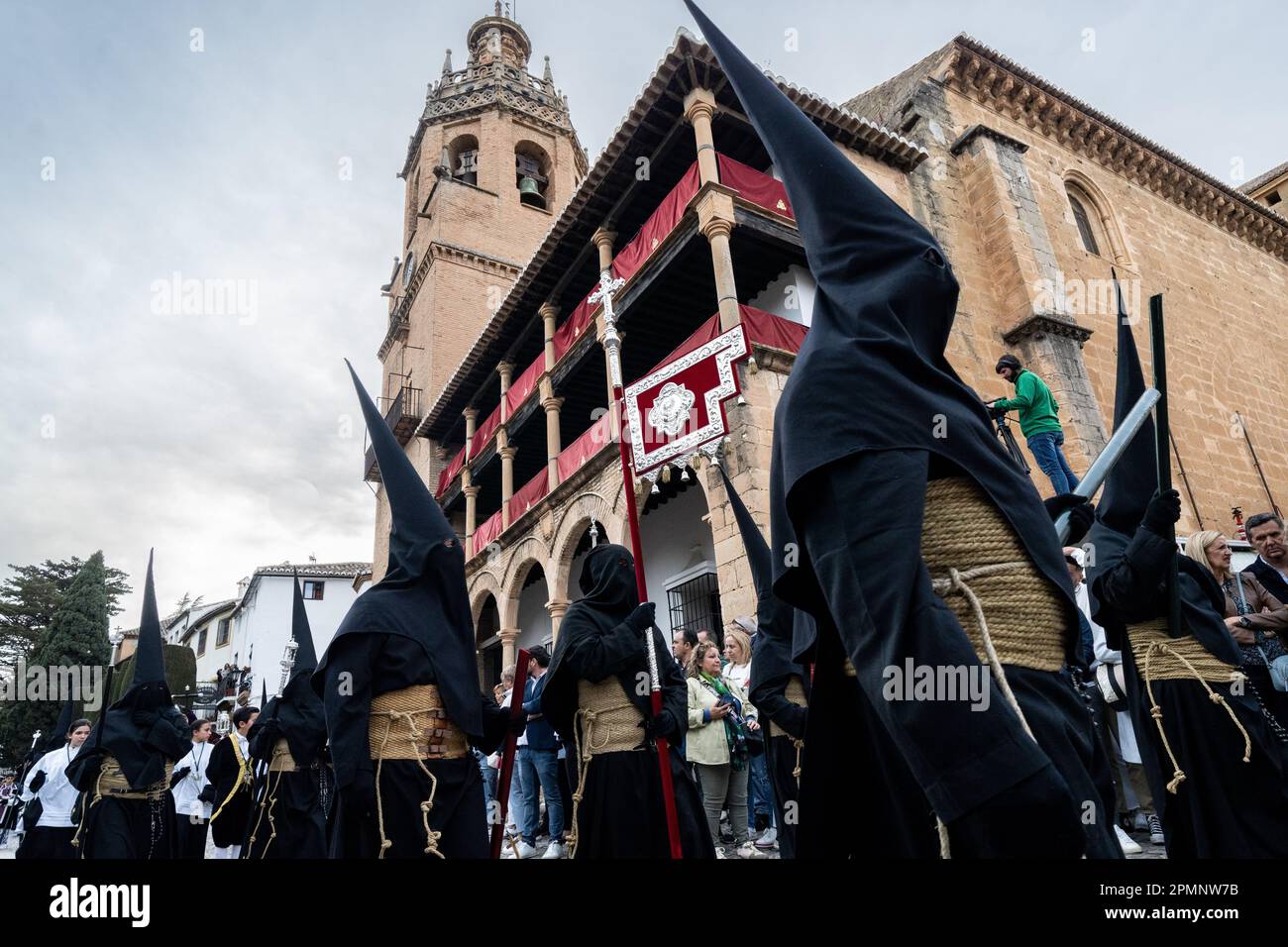 Penitents wearing black pointed hoods process past the St. Mary Major ...