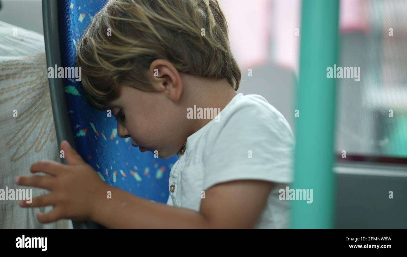 One tired bored child sitting inside bus transportation. Little boy ...