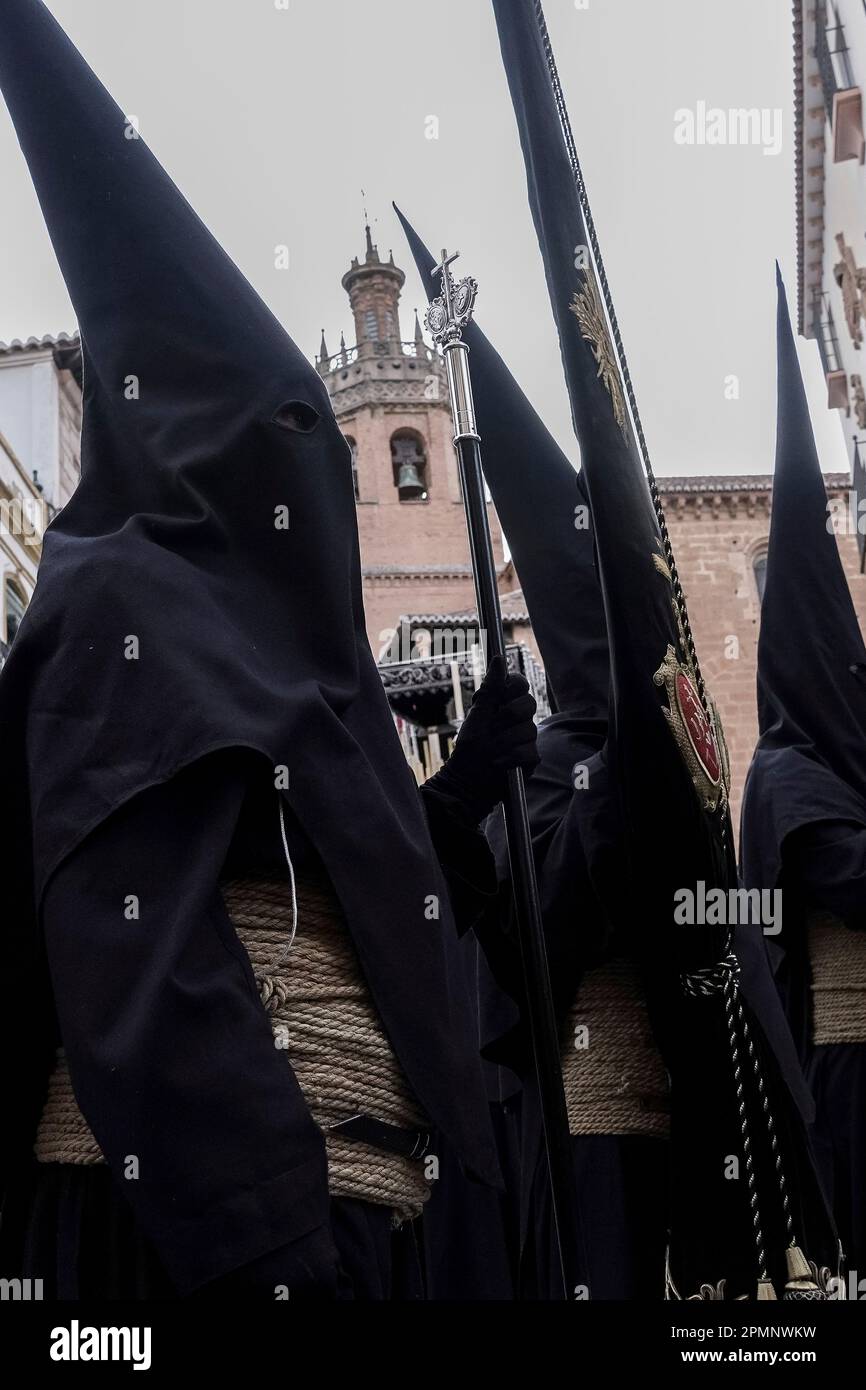 Penitents wearing black pointed hoods process past the St. Mary Major ...
