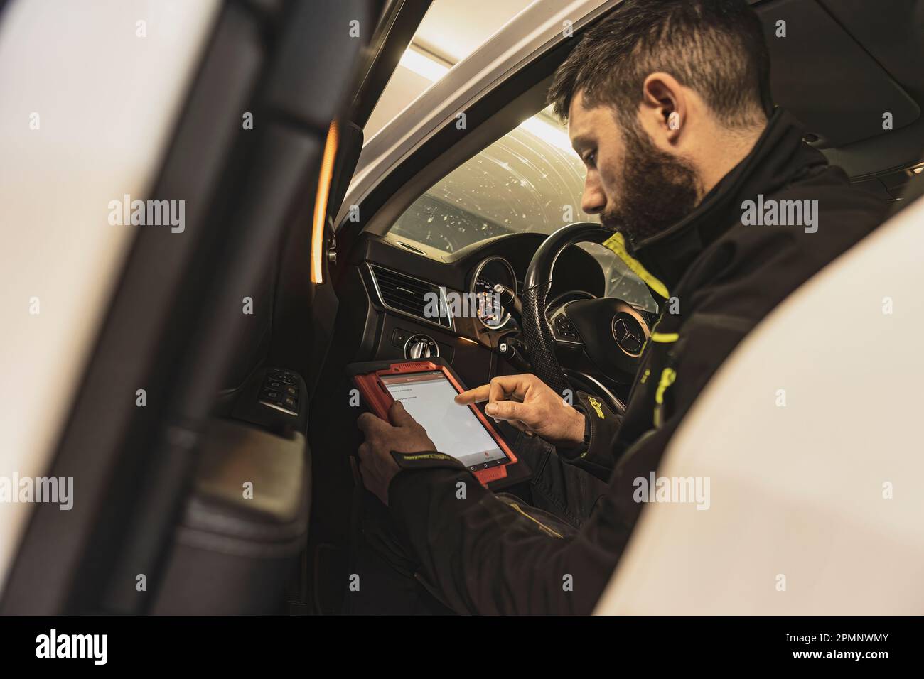 Milan, Italy 11 april 2023: A mechanic's hands use a diagnostic tool to ...