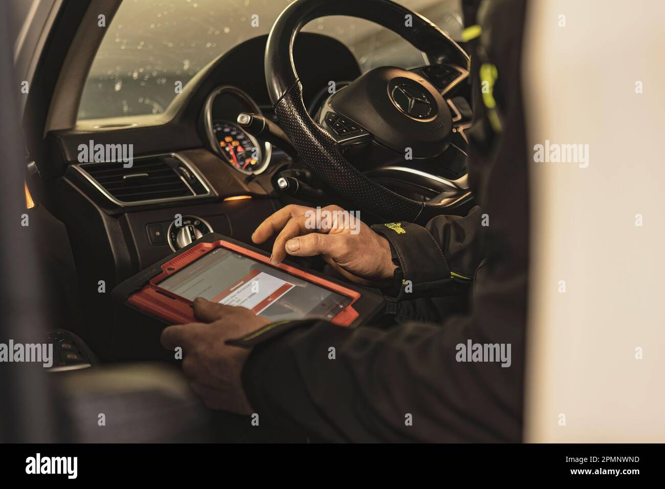 Milan, Italy 11 april 2023: A mechanic's hands use a diagnostic tool to ...