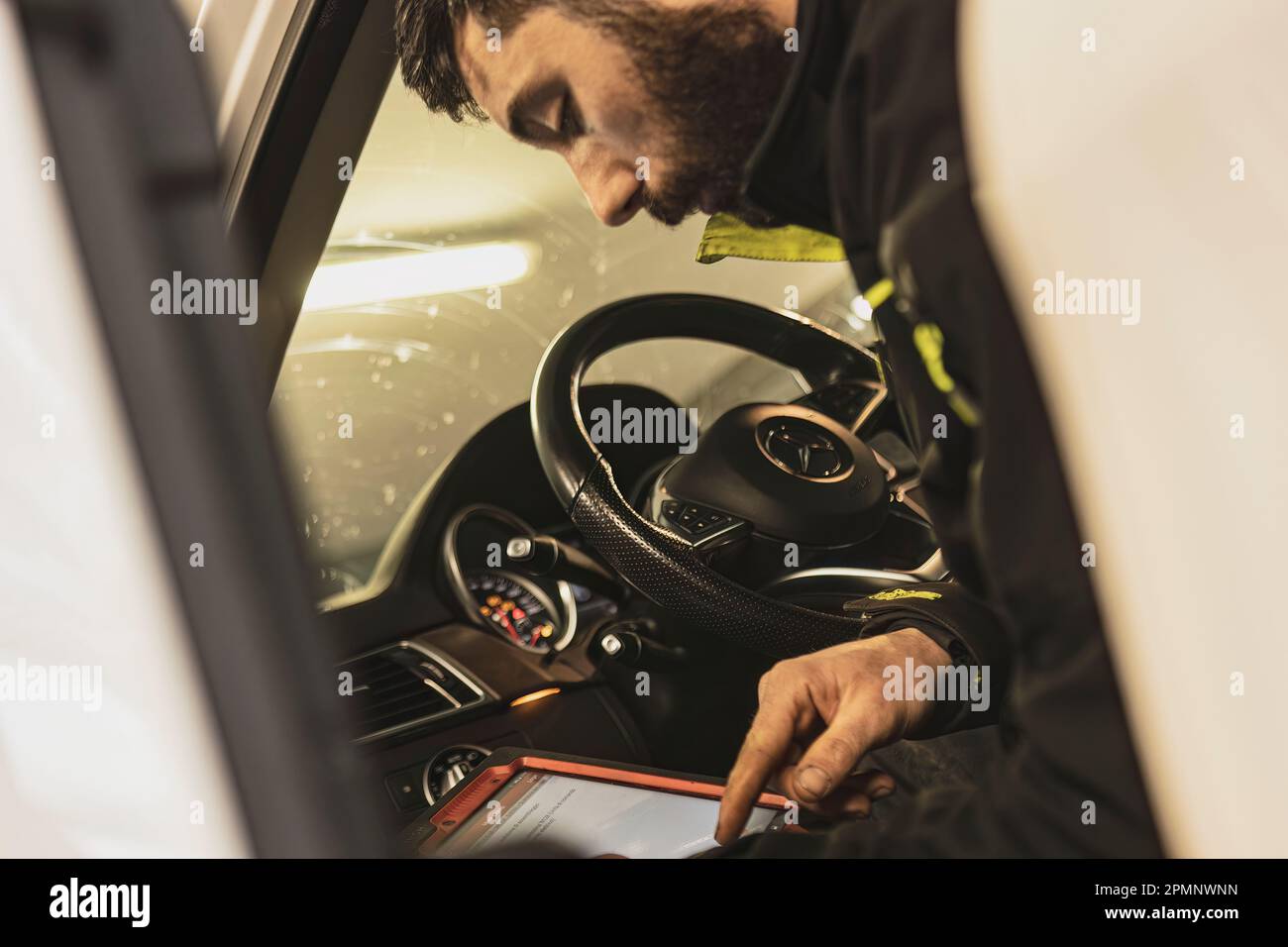Milan, Italy 11 april 2023: A mechanic's hands use a diagnostic tool to ...
