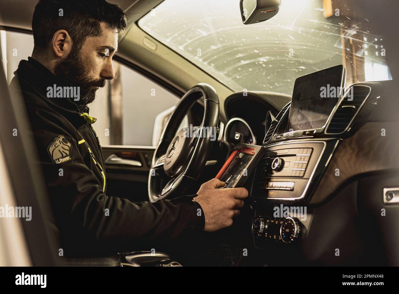 Milan, Italy 11 april 2023: A mechanic's hands use a diagnostic tool to ...