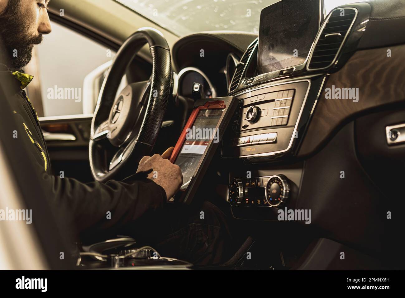 Milan, Italy 11 april 2023: A mechanic's hands use a diagnostic tool to ...