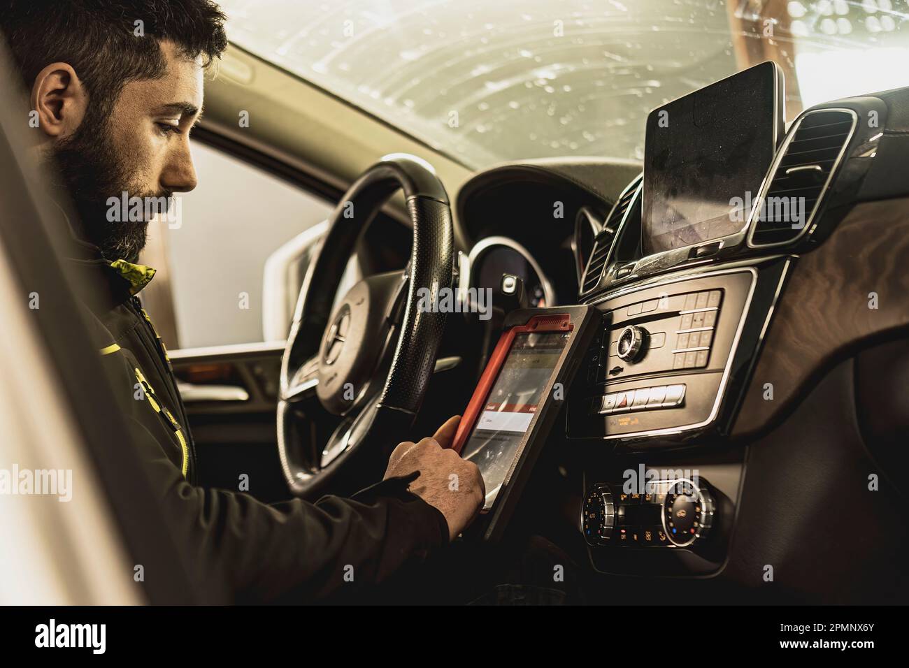 Milan, Italy 11 april 2023: A mechanic's hands use a diagnostic tool to ...