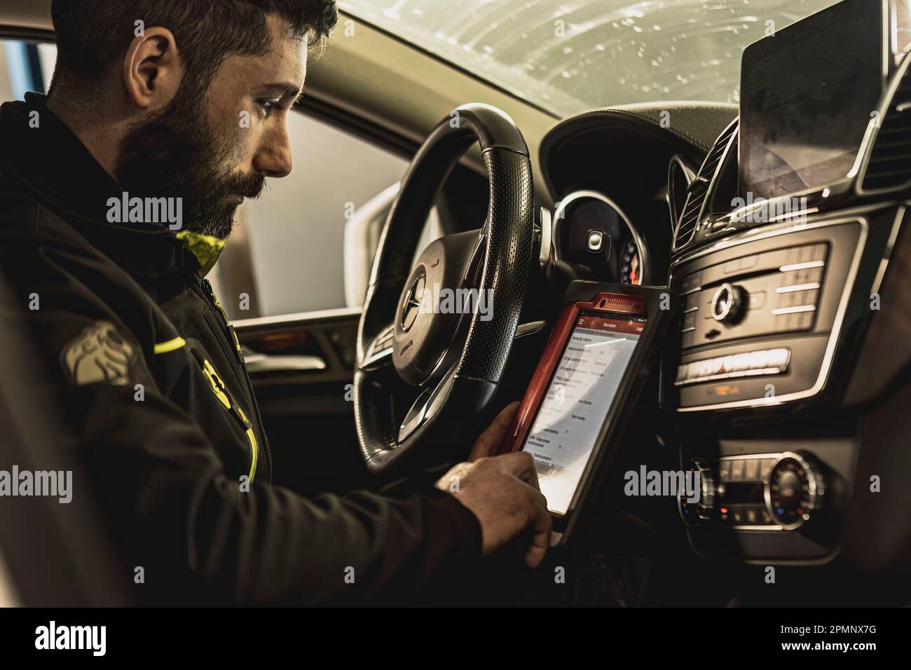 Milan, Italy 11 april 2023: A mechanic's hands use a diagnostic tool to ...