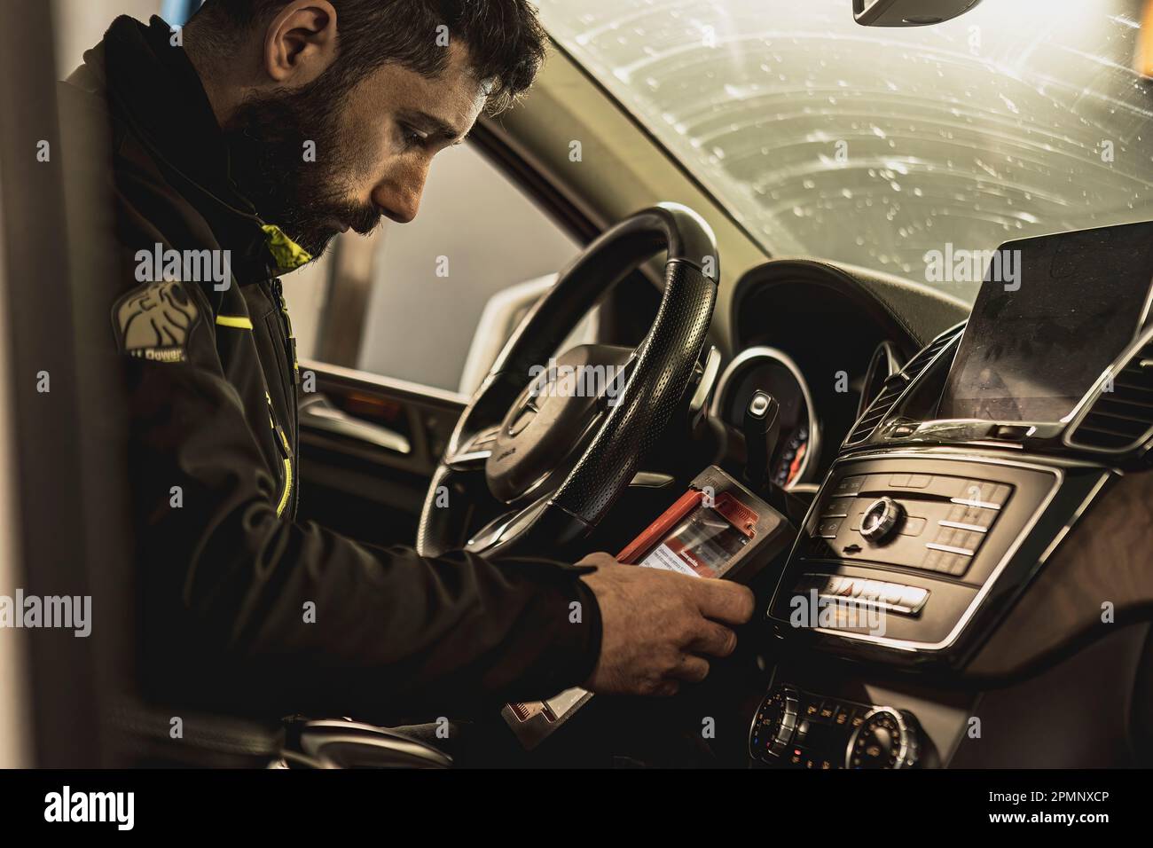 Milan, Italy 11 april 2023: A mechanic's hands use a diagnostic tool to ...