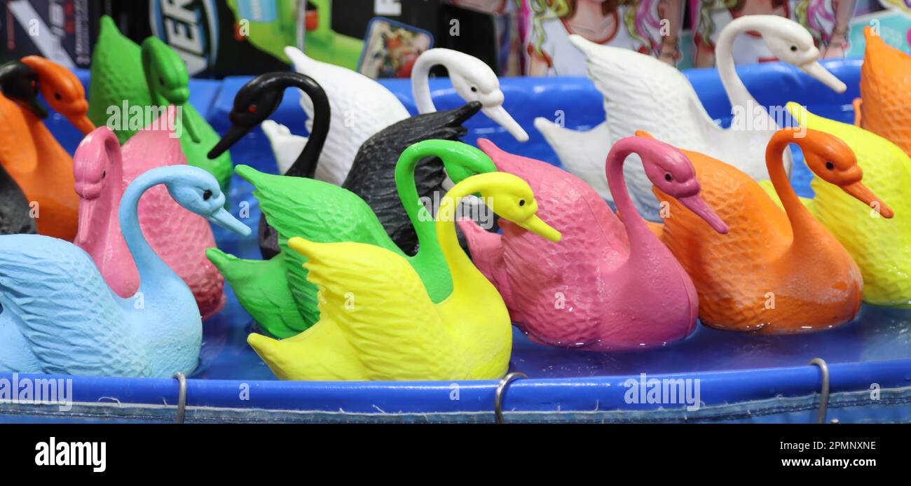 A container full of colorful swan toys arranged in an organized manner ...