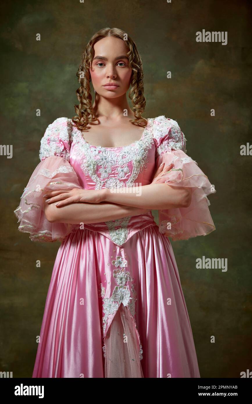 Shot of beautiful woman wearing vintage pink dress and standing with ...