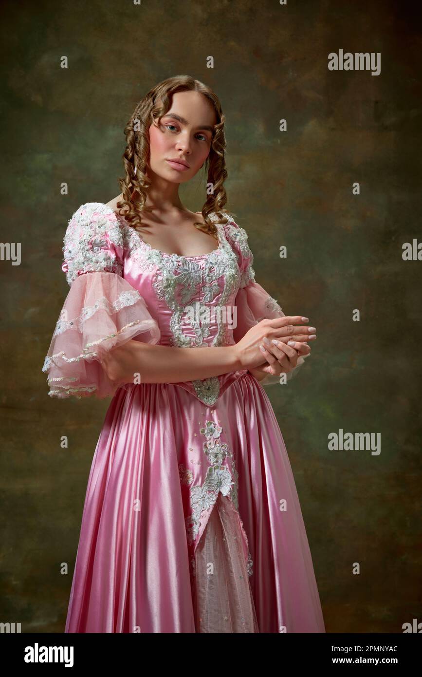 Shot of adorable blond girl wearing fancy pink dress and standing with ...