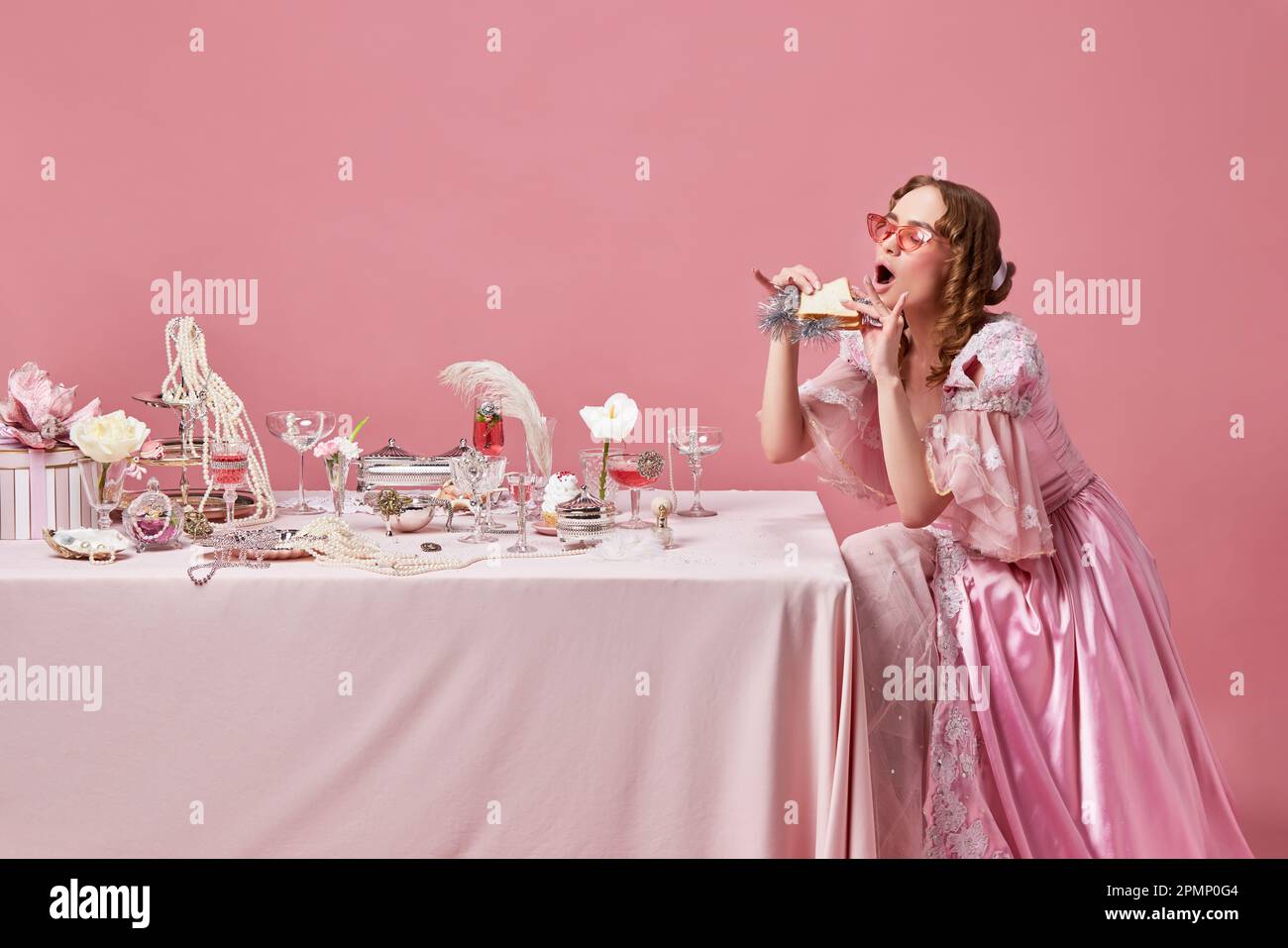 Portrait of beautiful, hungry, blond princess wearing fancy pink dress ...