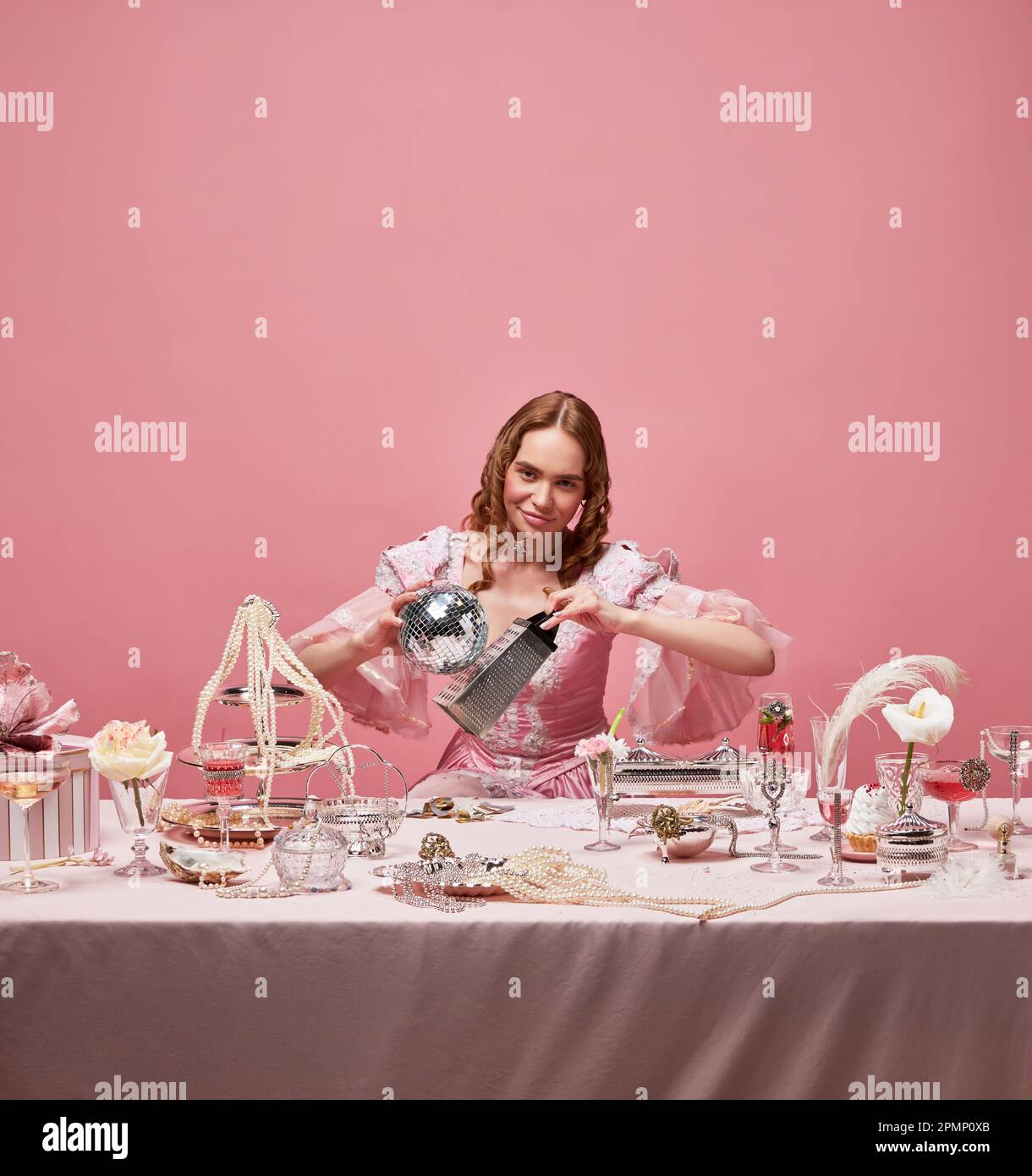 Portrait of queen wearing pink dress sitting at table and doing crazy ...