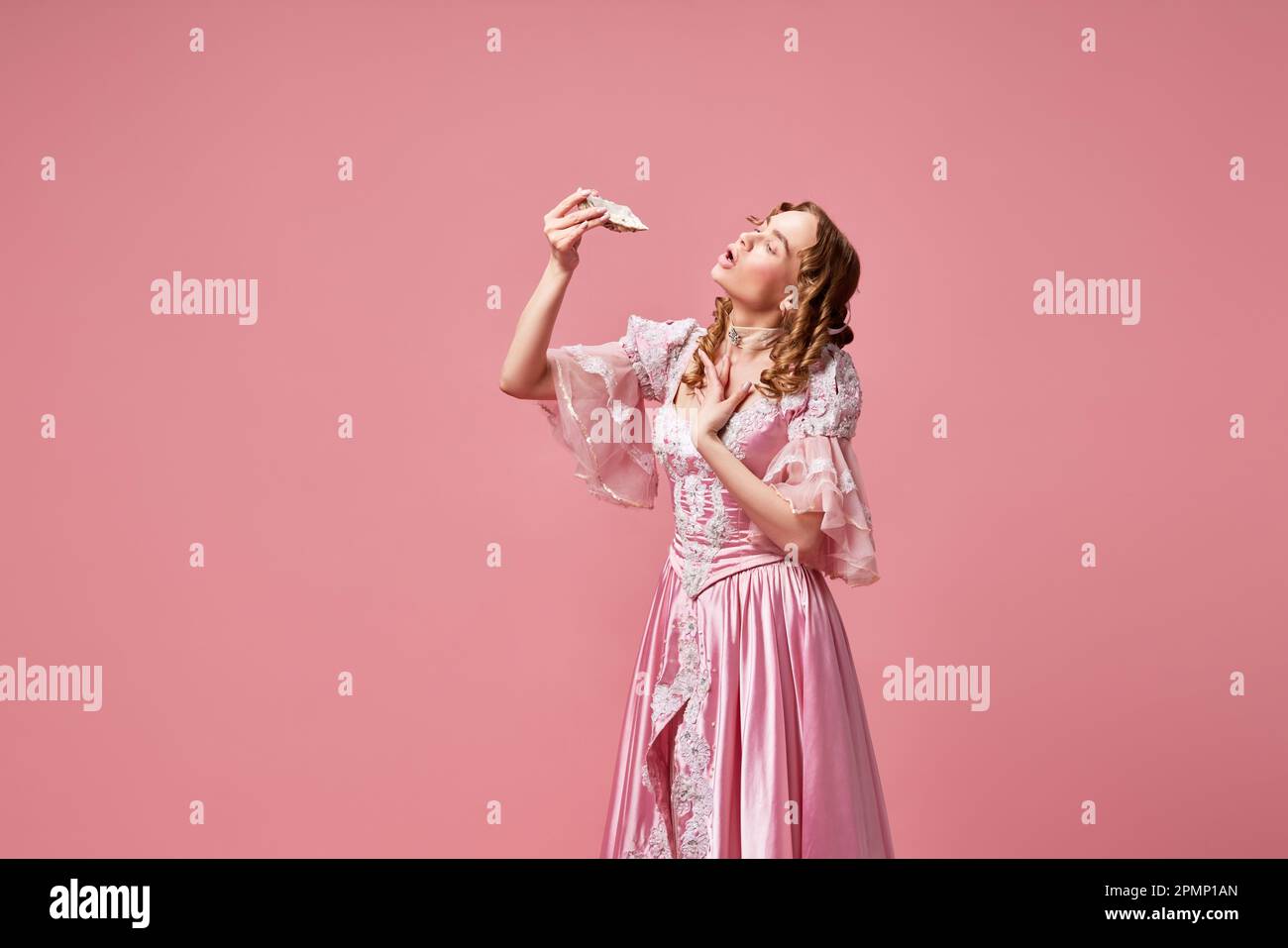 Shot of beautiful young princess wearing pretty dress and eating ...