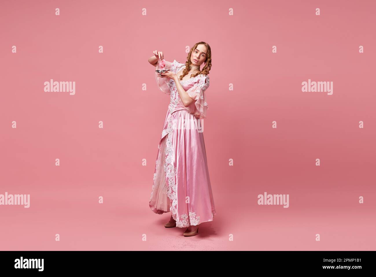 Hungry fairy tale blond princess wearing renaissance dress eating ...